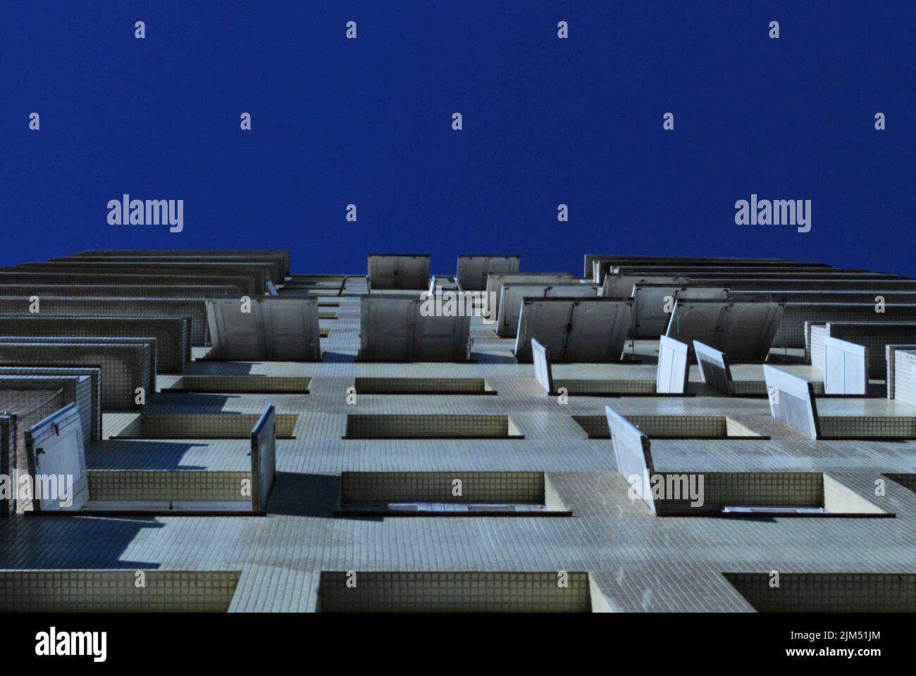 White building seen from below with the windows open with the sky in ...