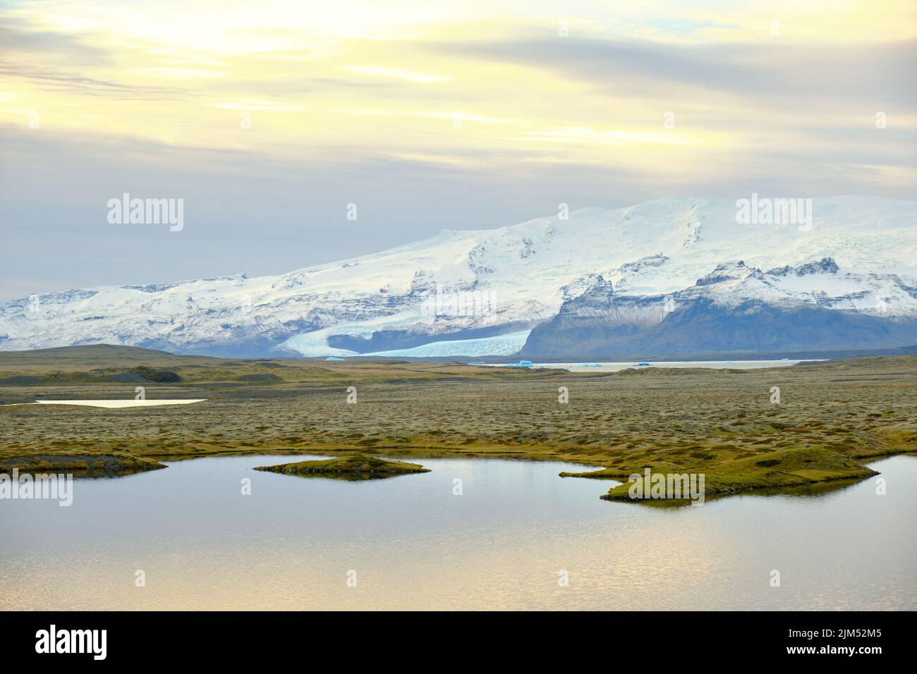 Snowy mountain behind reflective lak Stock Photo - Alamy