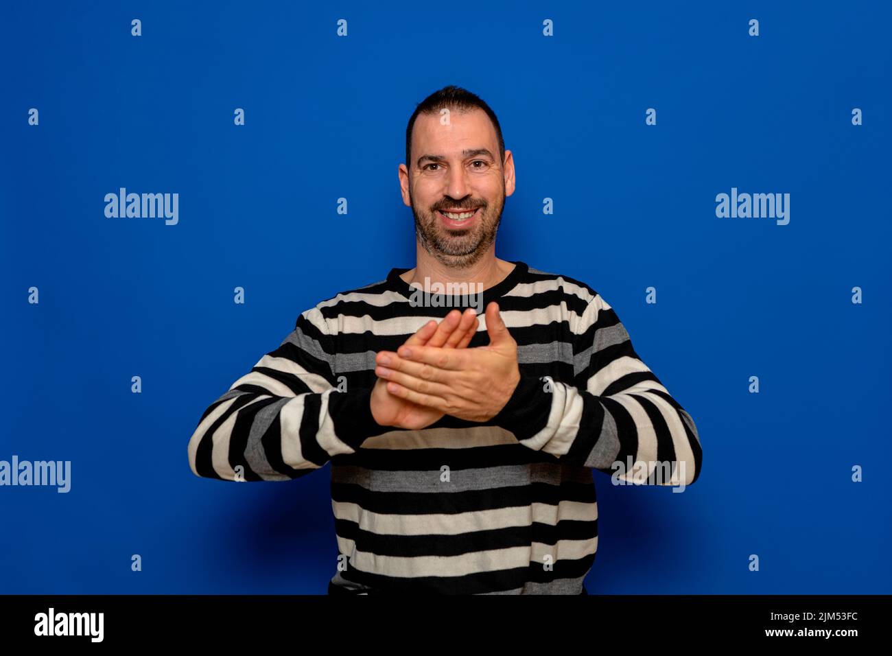 Handsome elegant man over isolated blue background. Clapping and ...