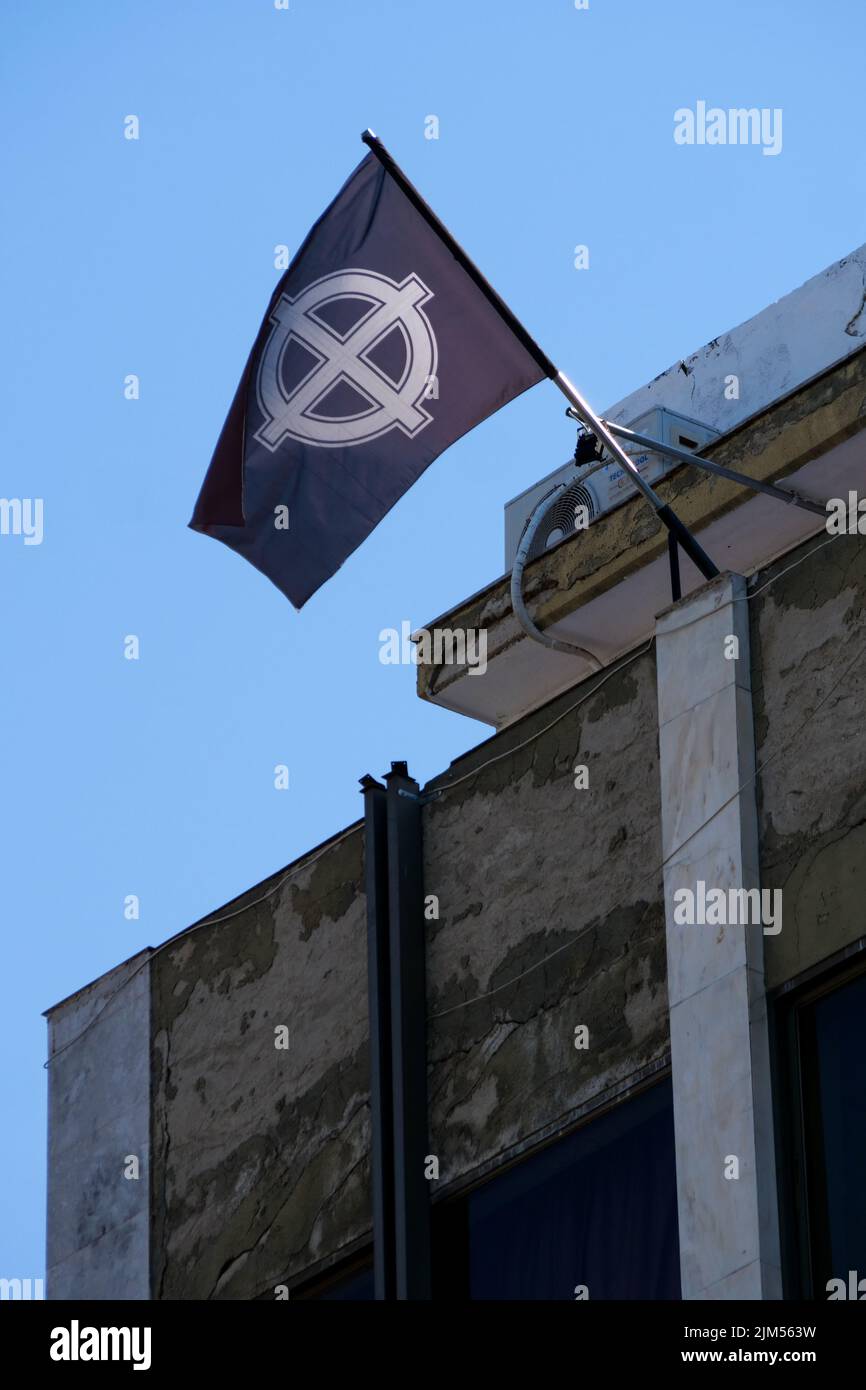 Far-right flag waving over a building facade, Palea Sfagia area ...
