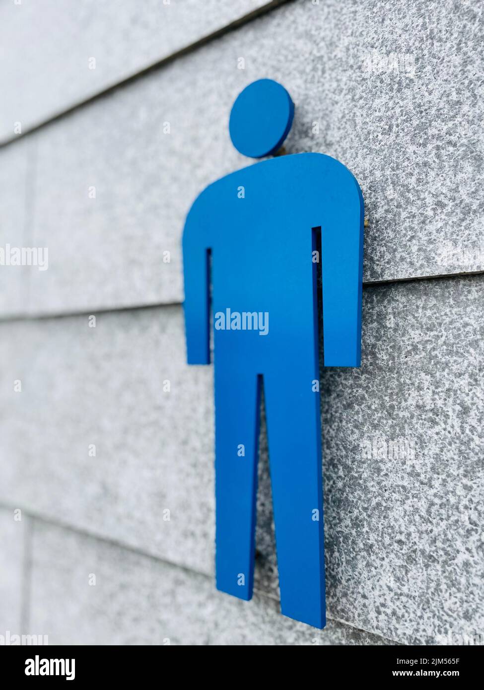 A vertical shot of a blue Men toilet logo in Japanese public restroom's ...
