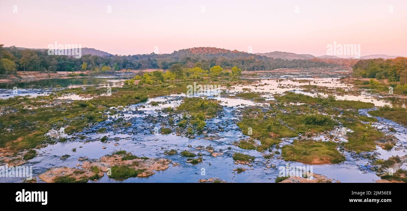 A beautiful natural view of a wetland with mountains in the background ...
