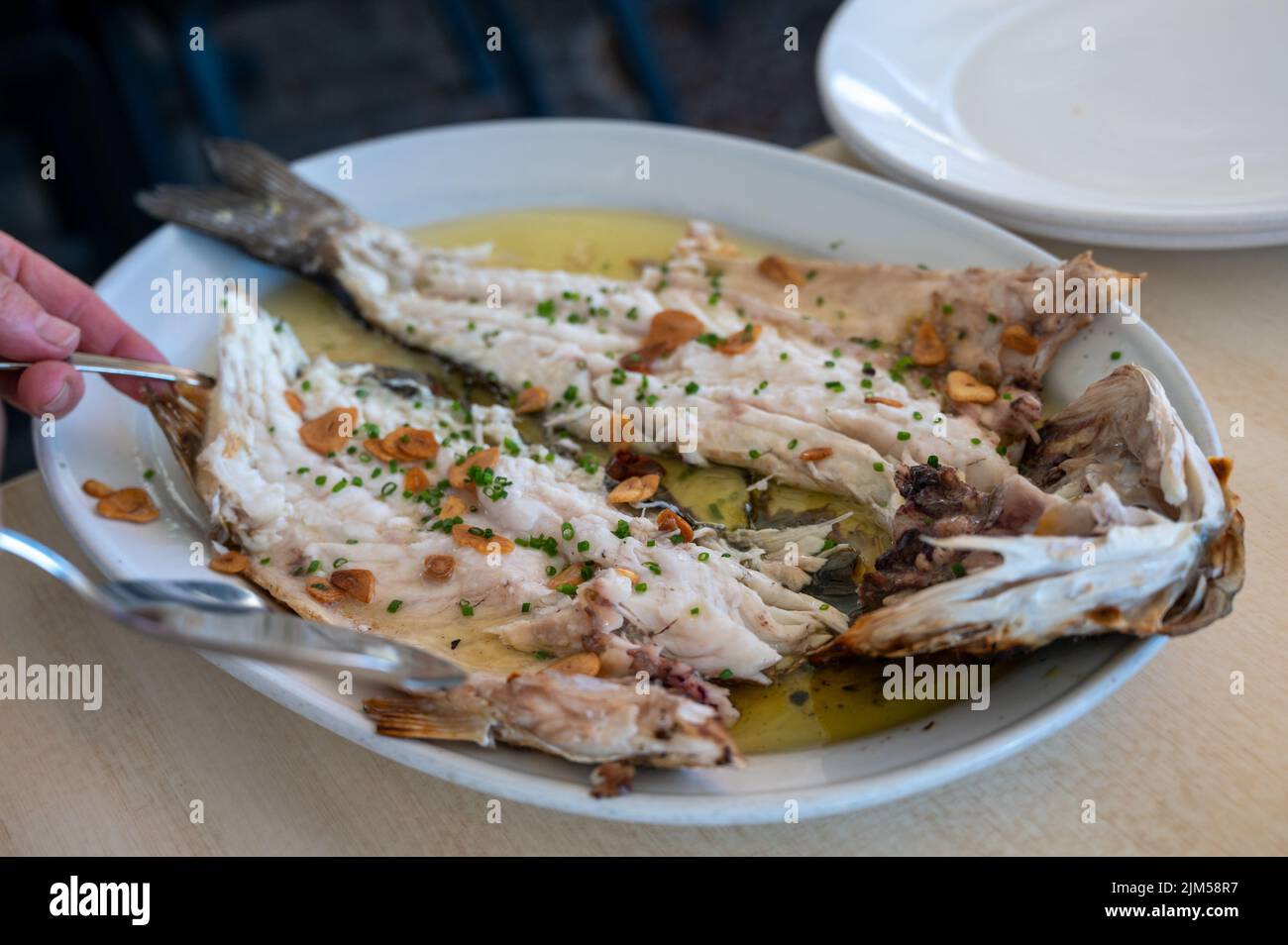 Serving in restaurant of fresh grilled with garlic and olive oil on old ...