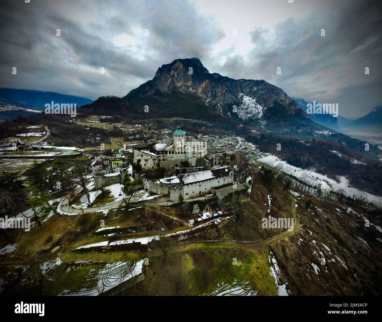 A bird's eye view of an old castle with mountains in the background ...
