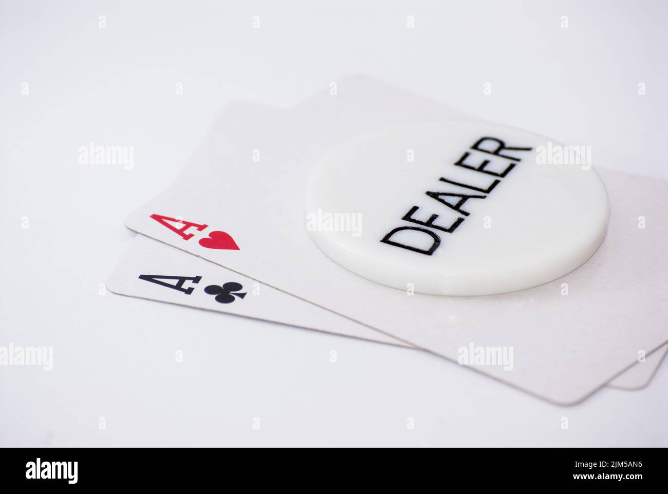 Two ace cards and a dealer chip on a white background Stock Photo - Alamy