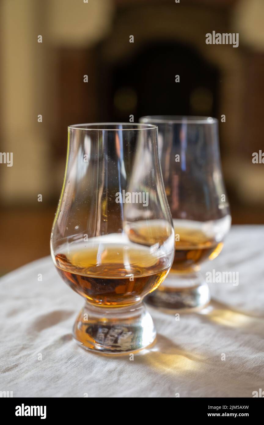 Two drams of scotch whiskey with view on fireplace in old house on ...