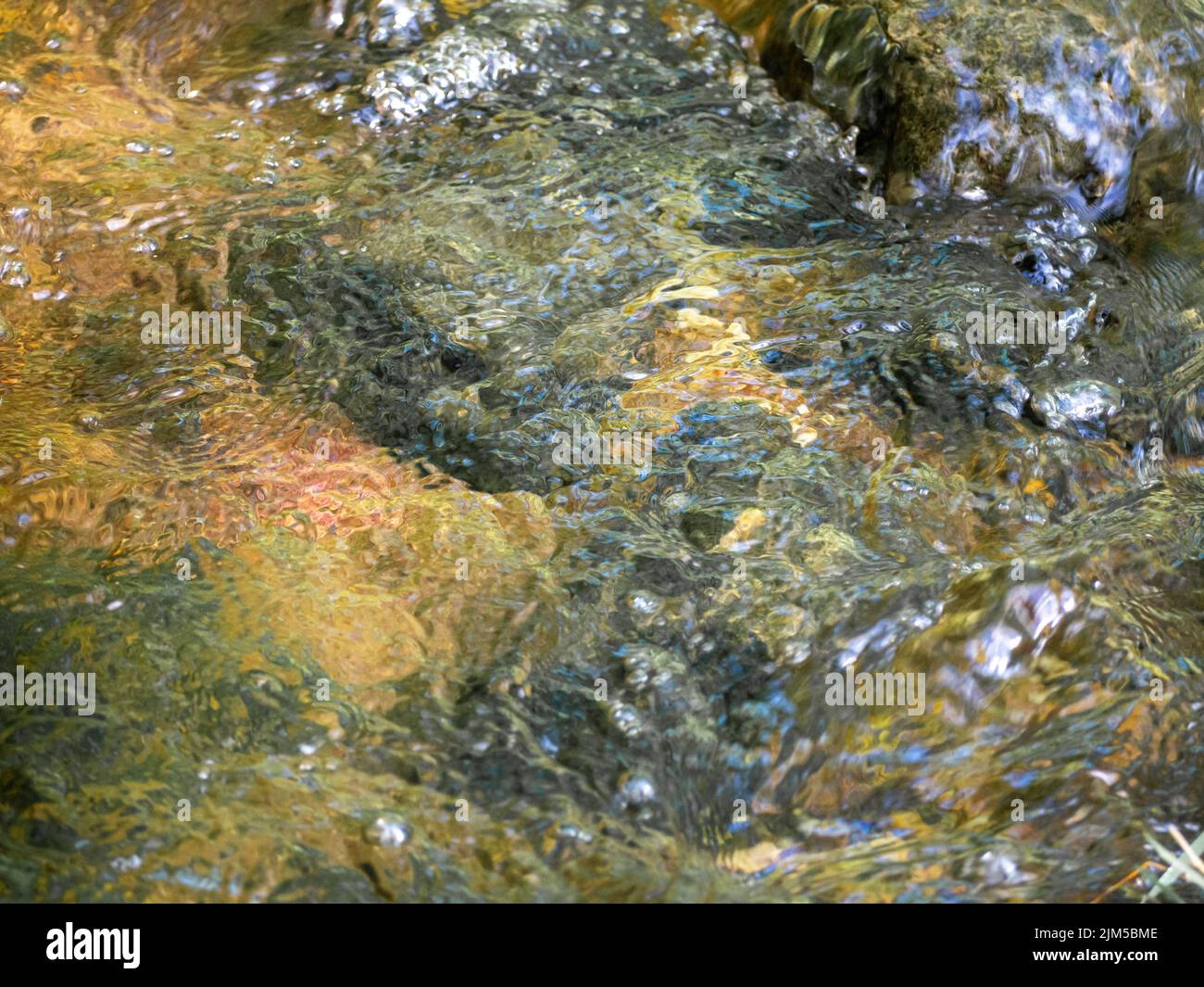 A closeup of fresh water from a natural spring flowing through the ...