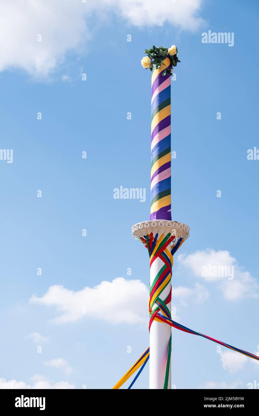 A vertical shot of colorful strings on a traditional English Maypole ...