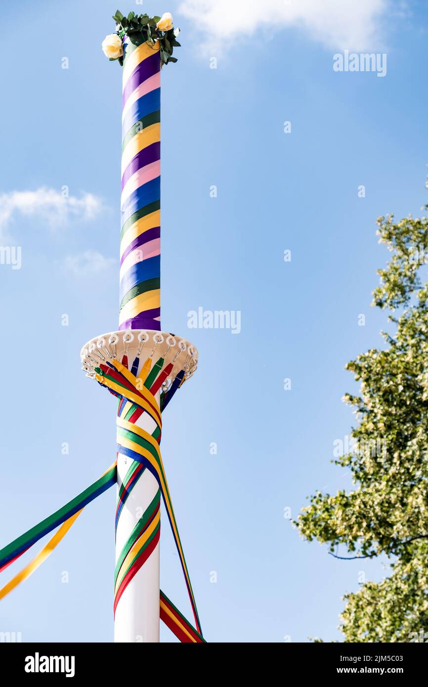 A vertical shot of colorful strings on a traditional English Maypole ...
