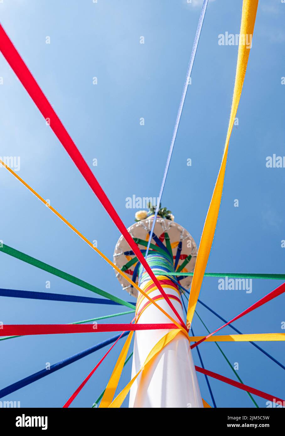 A low angle shot of a pole with colored ribbons on a traditional ...