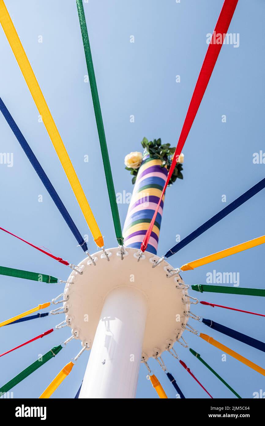 A low angle shot of a pole with colored ribbons on a traditional ...