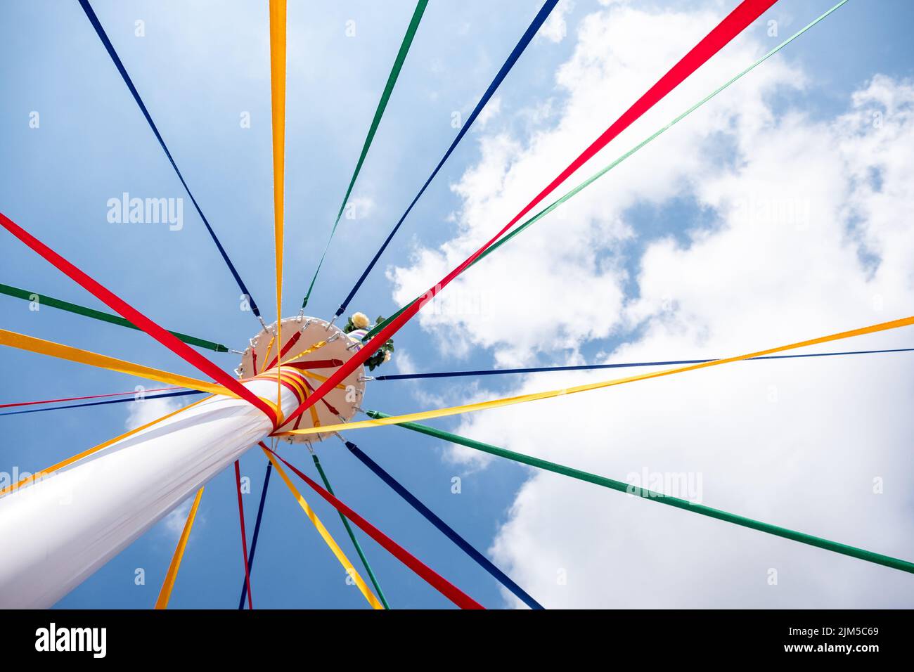 A low angle shot of a pole with colored ribbons on a traditional ...