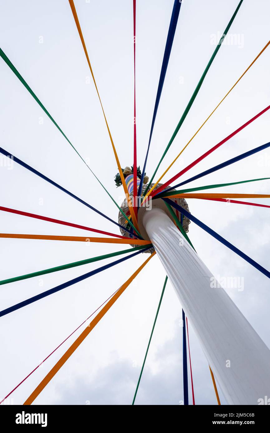A low angle shot of a pole with colored ribbons on a traditional ...
