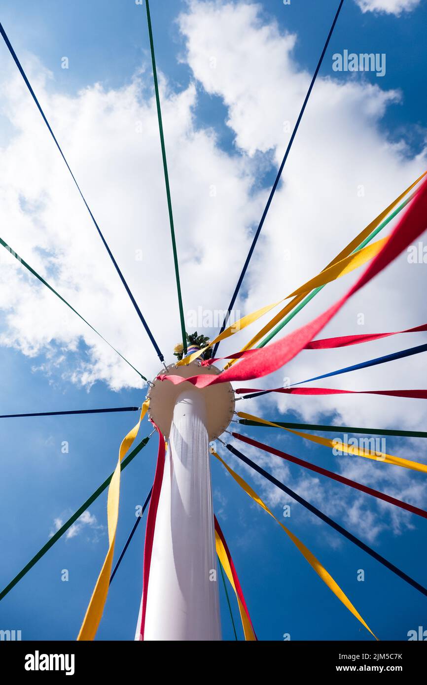 A low angle shot of a pole with colored ribbons on a traditional ...