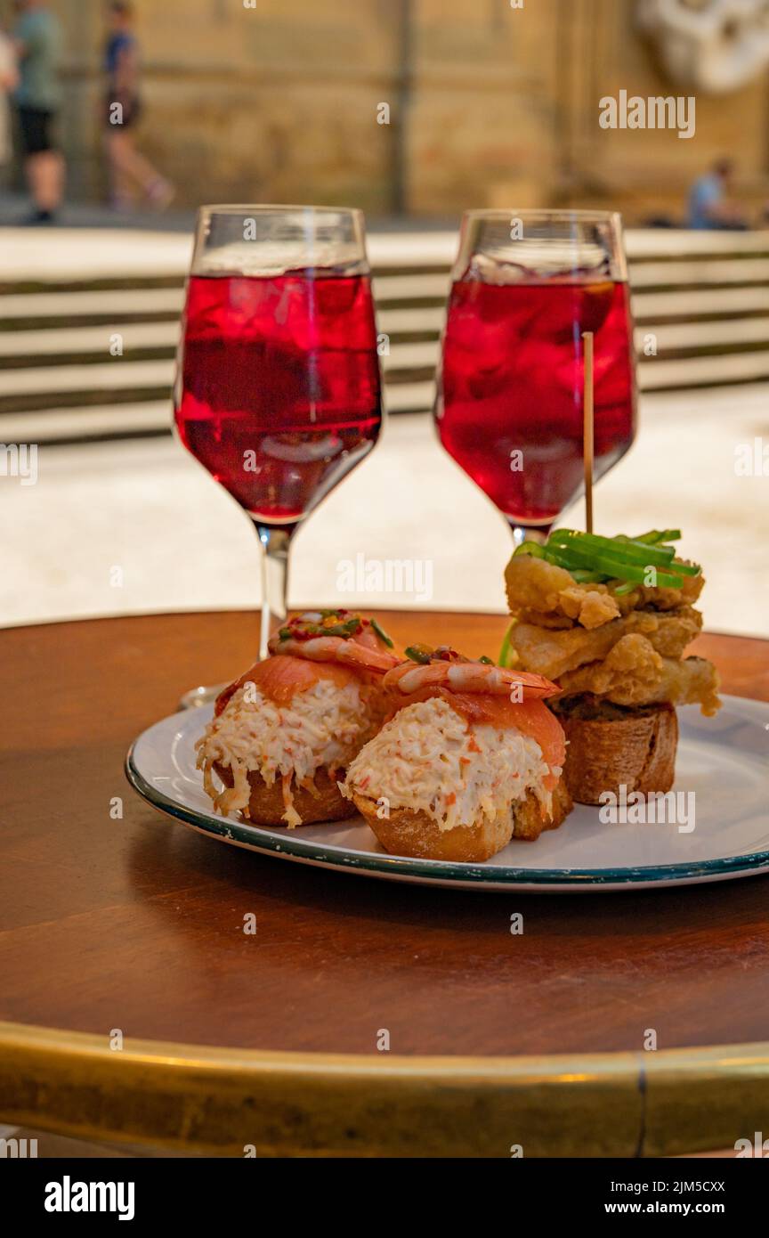 Glasses of cold sangria wine served outdoor with pinchos tapas in bar ...