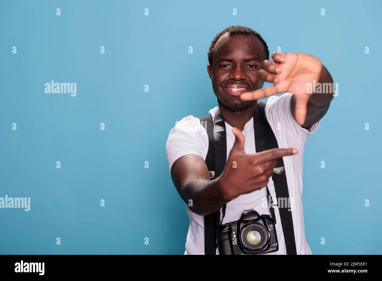 Happy african american photographer doing frame hand gesture with ...