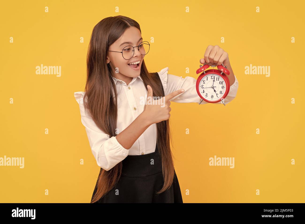 punctual teen girl checking time. happy nerd child pointing finger on ...