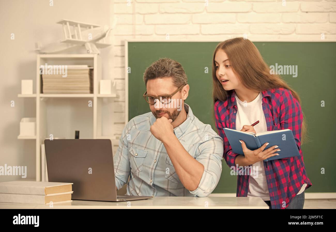 family help. dad and daughter use notebook. back to school. childhood ...