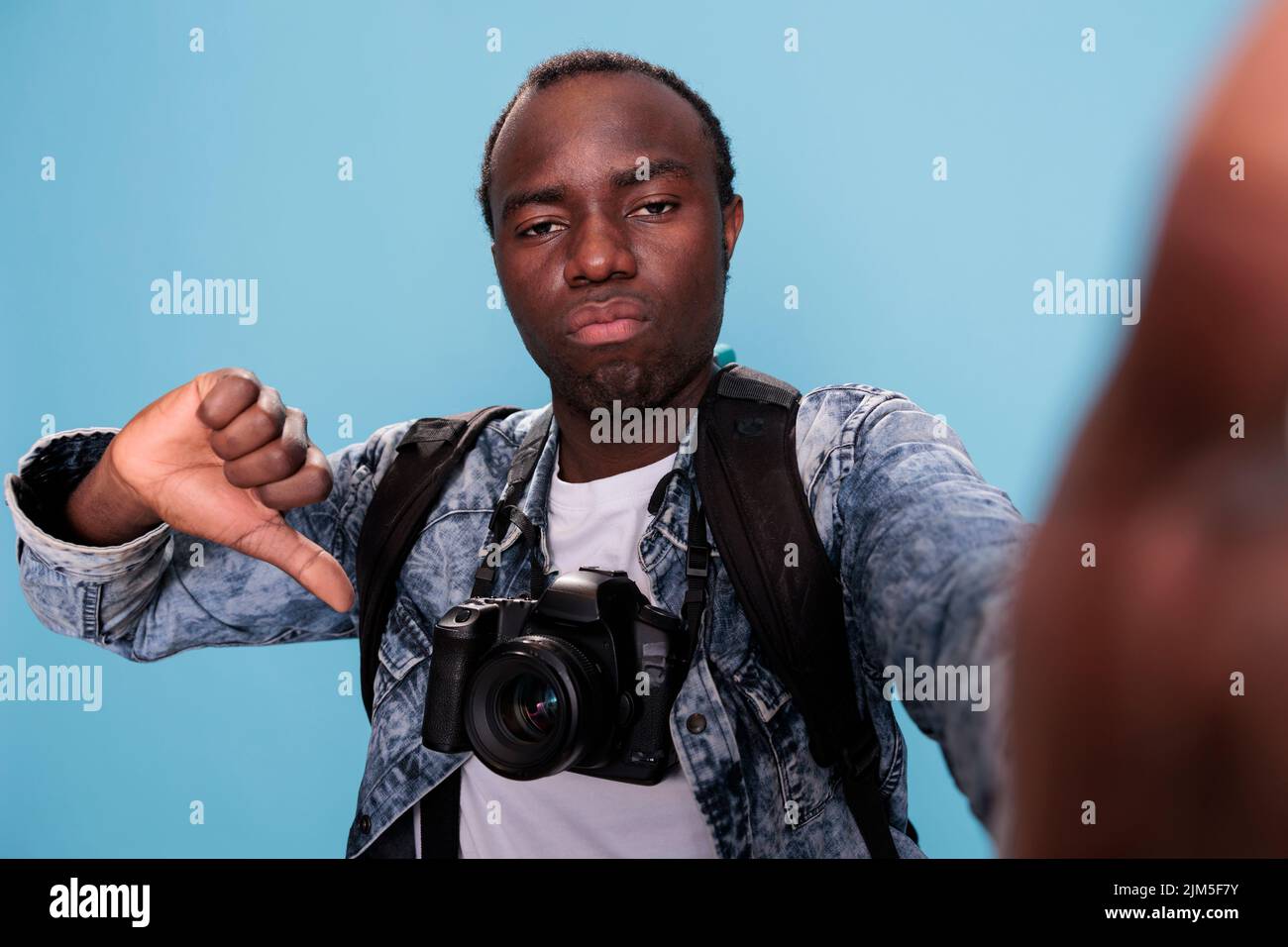 African american photography enthusiast with DSLR device showing thumbs ...