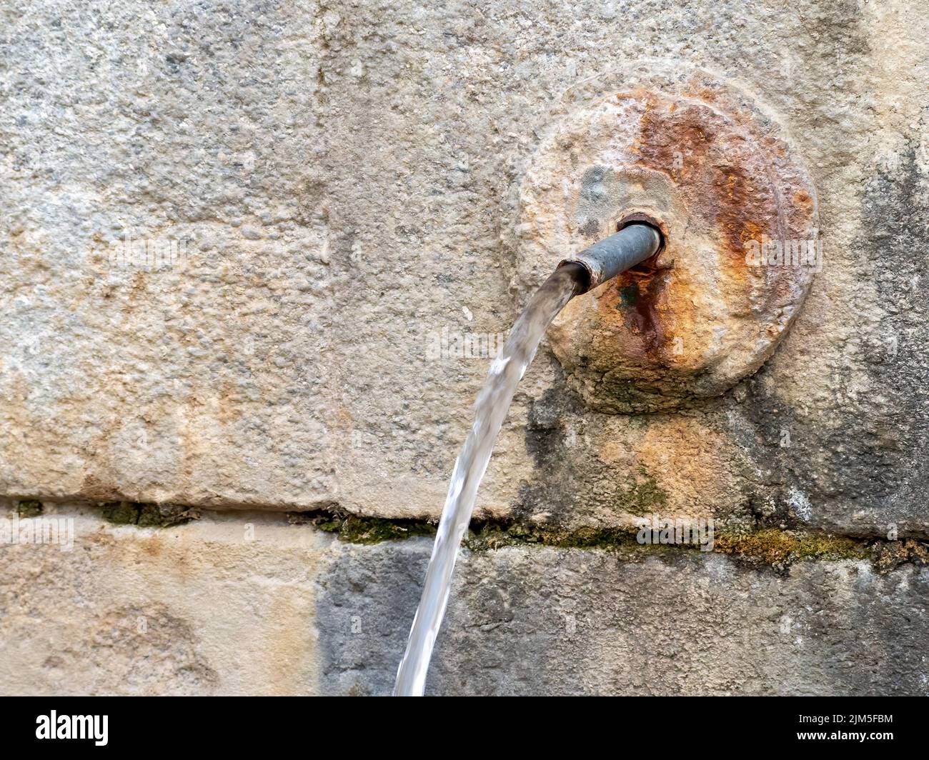 A closeup shot of an old water fountain with a roman water tap for ...