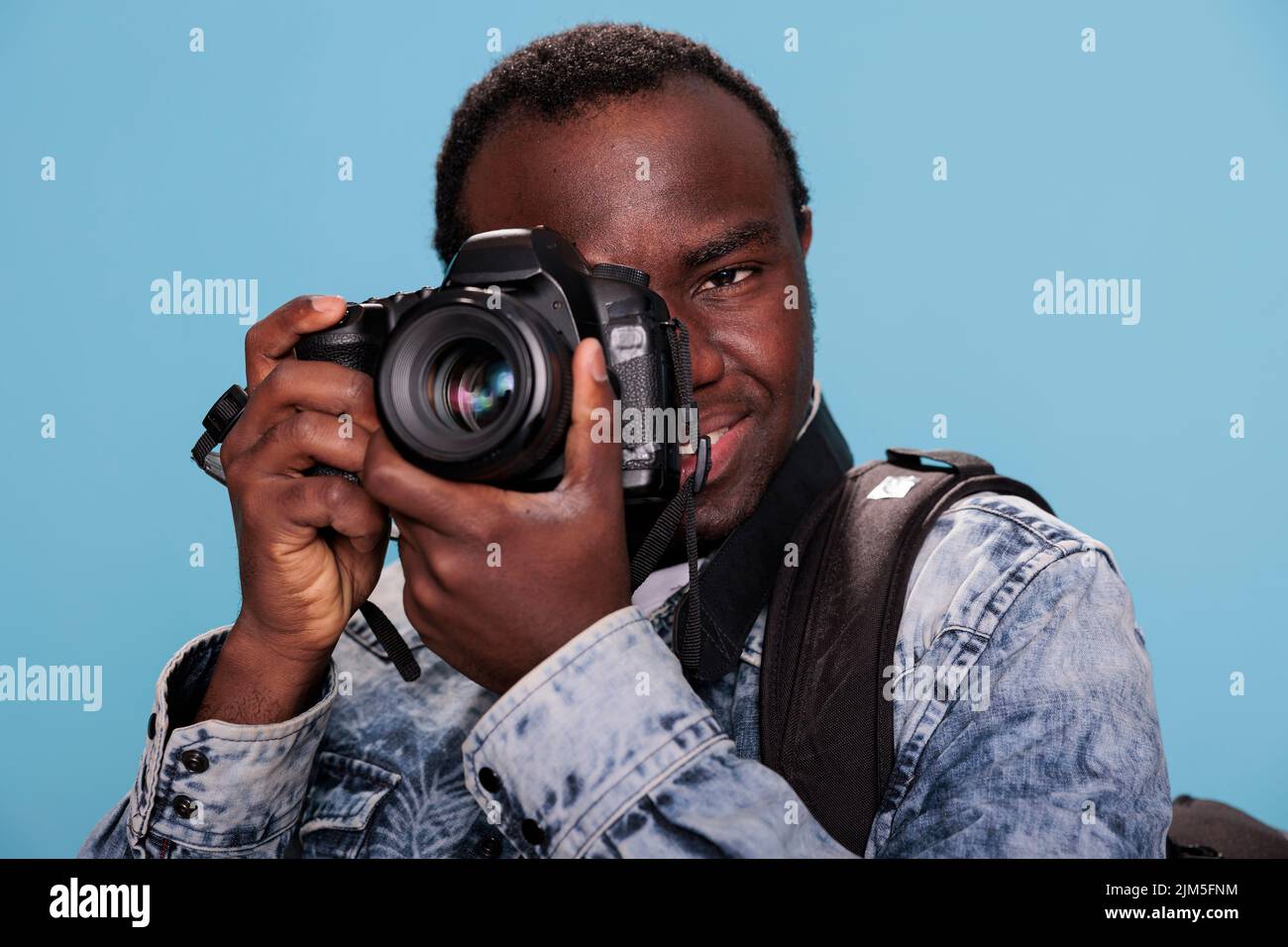 Photography enthusiast taking photo with DSLR camera while standing on ...