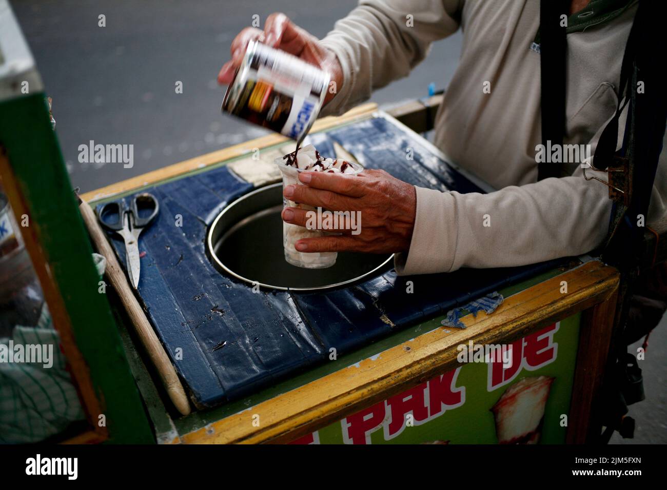 Traditional Indonesian ice cream seller serving customers Stock Photo ...
