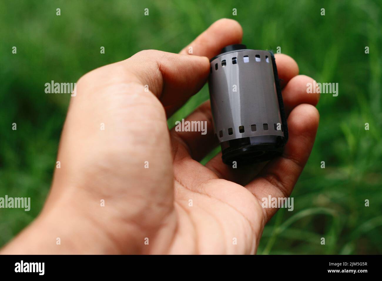 Close up of hand holding film negatives or film canisters Stock Photo ...