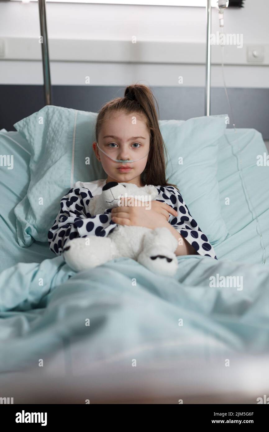 Sick little girl under treatment wearing oxygen tube while holding ...
