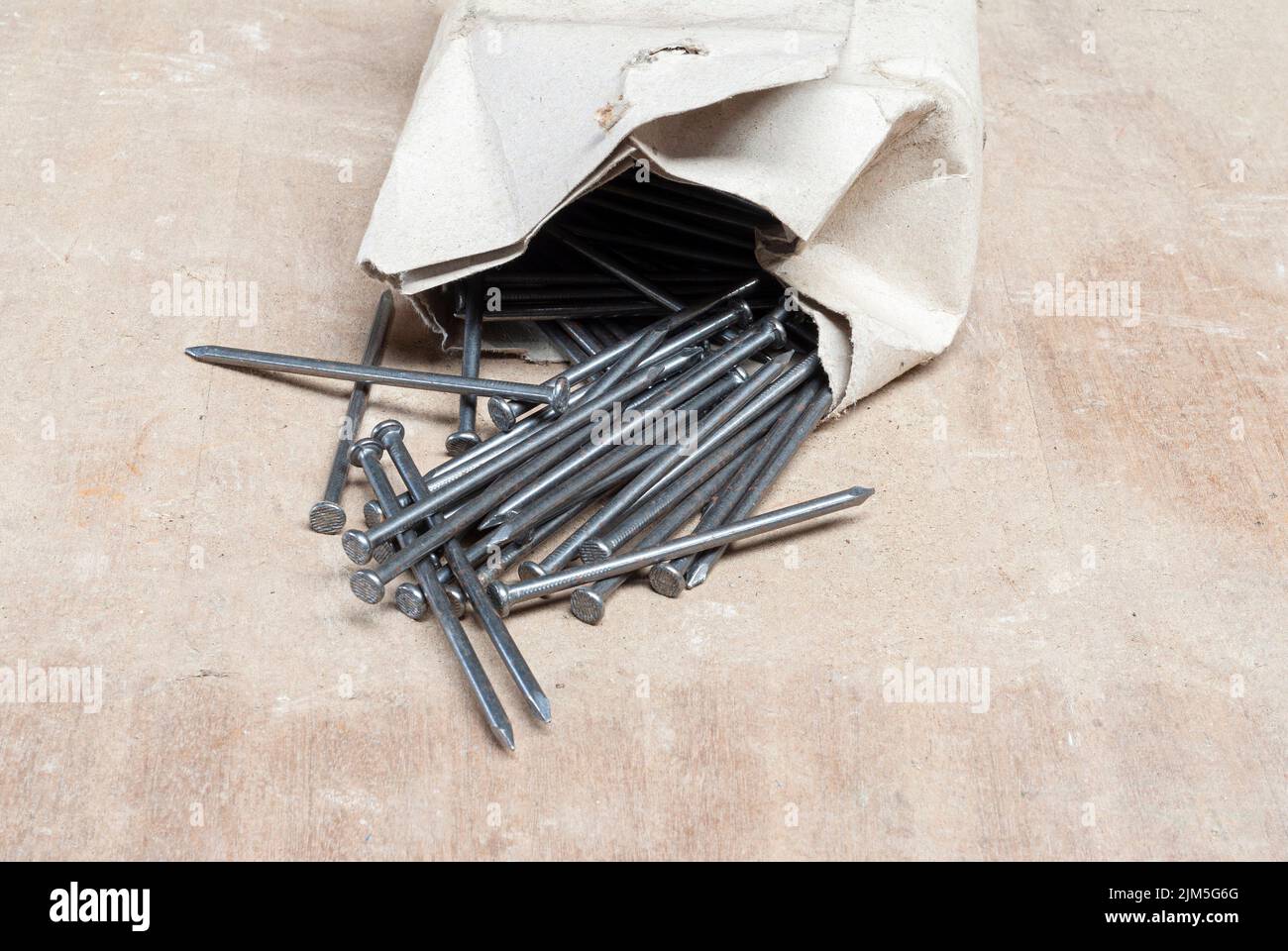 A carton box with nails on a wood background Stock Photo - Alamy