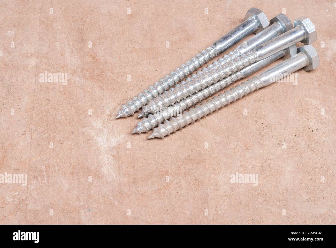 A pile of galvanized wood screws on a textured brown background Stock ...