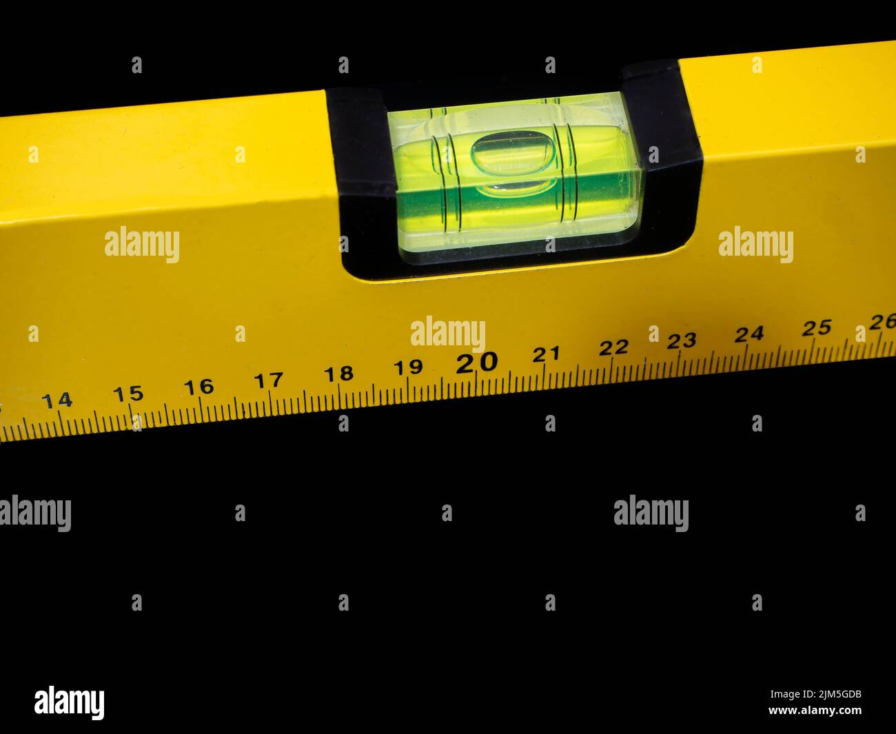 A yellow spirit level isolated on black background Stock Photo - Alamy
