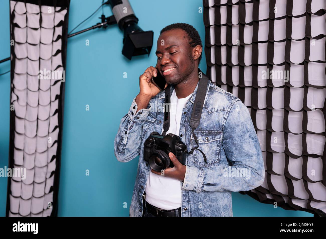 Young producer having a phone call while working on production studio ...