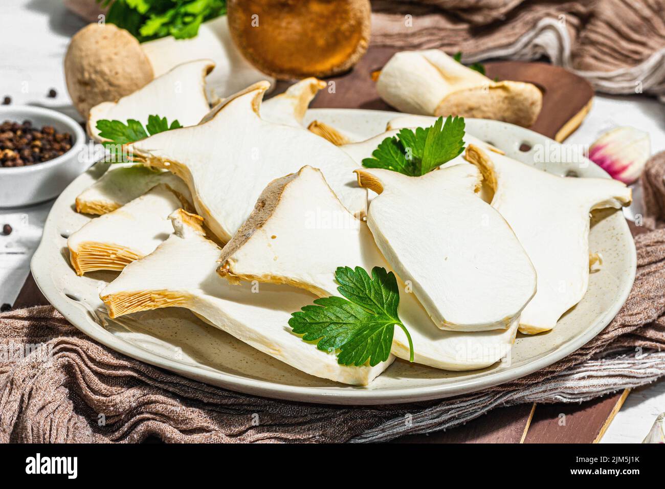 Fresh Pleurotus eryngii mushrooms on white wooden background. Raw king ...