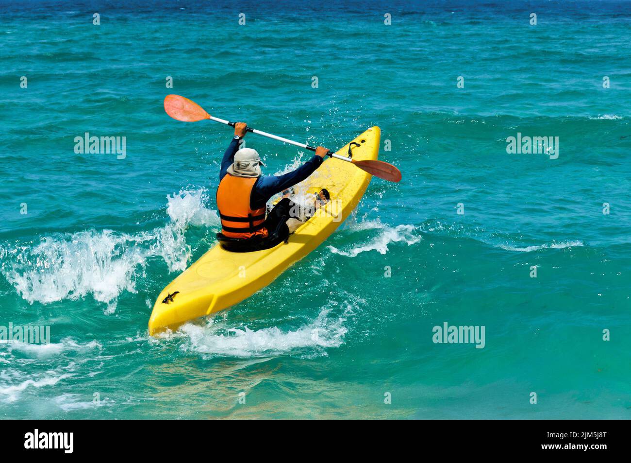 athlete compete in the kayak with sea waves trying to swim away from ...
