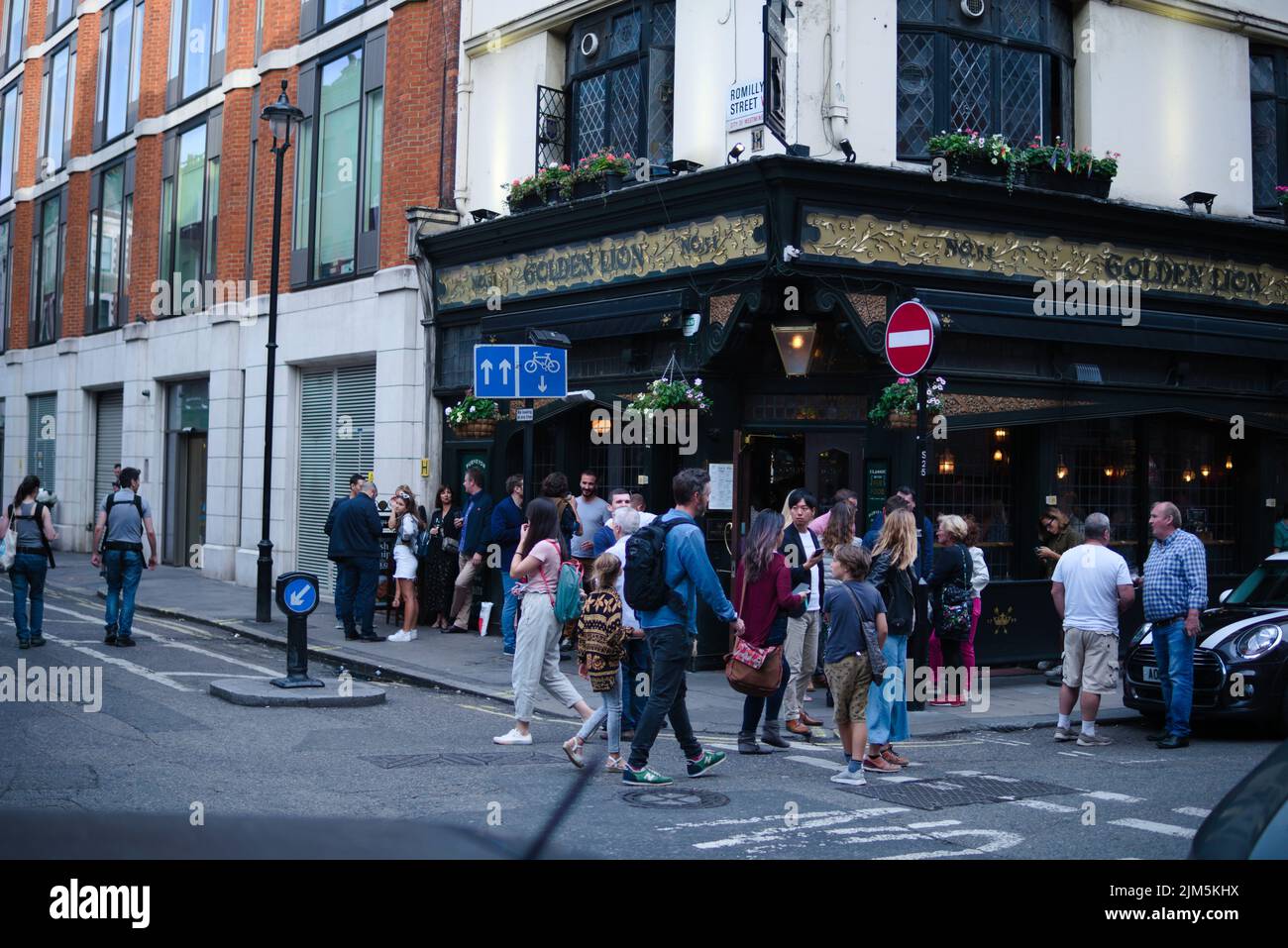 A crowd of people gathered in front of an authentic Golden Lion pub in ...