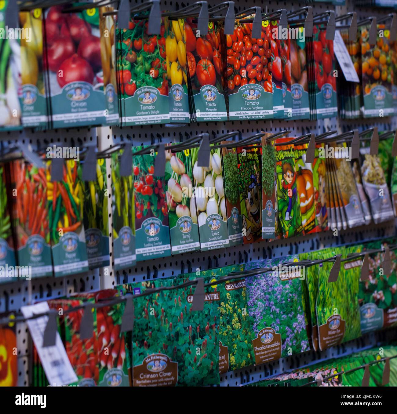 Close-up of rows of seed packets for sale in a gardening shop interior ...