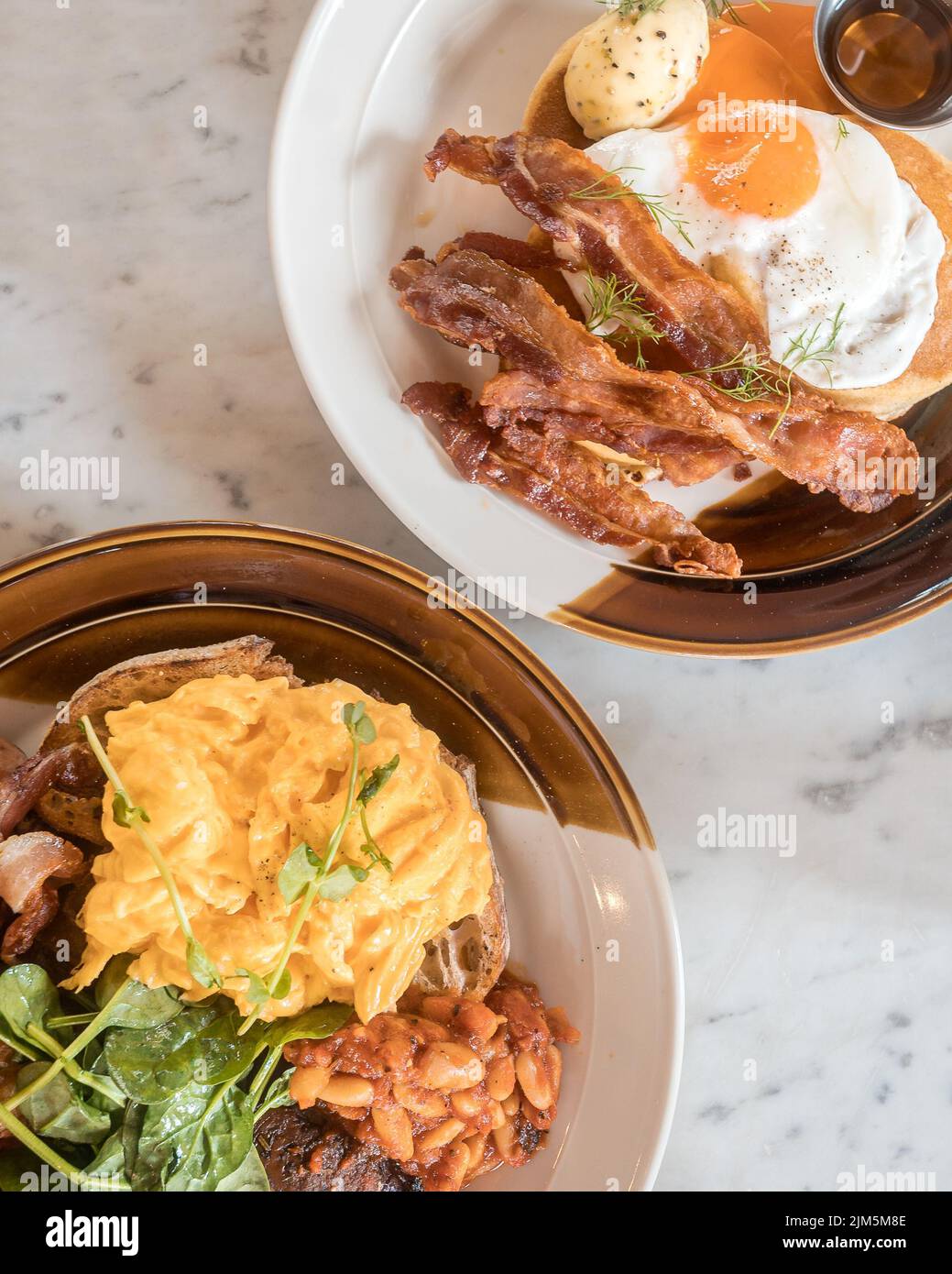 A top view of two plates of delicious food with meat, vegetable and egg ...