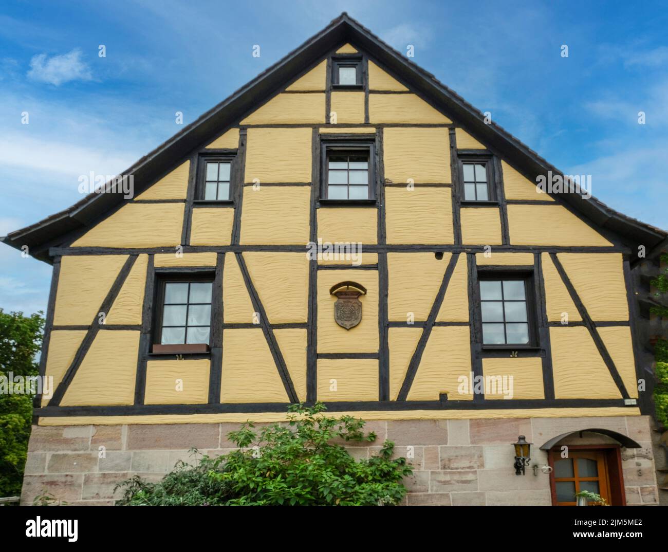 The front facade of the typical half-timbered building against a blue ...