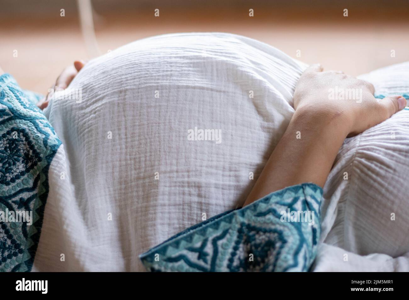 A shallow focus shot of the female touching her pregnant belly Stock ...