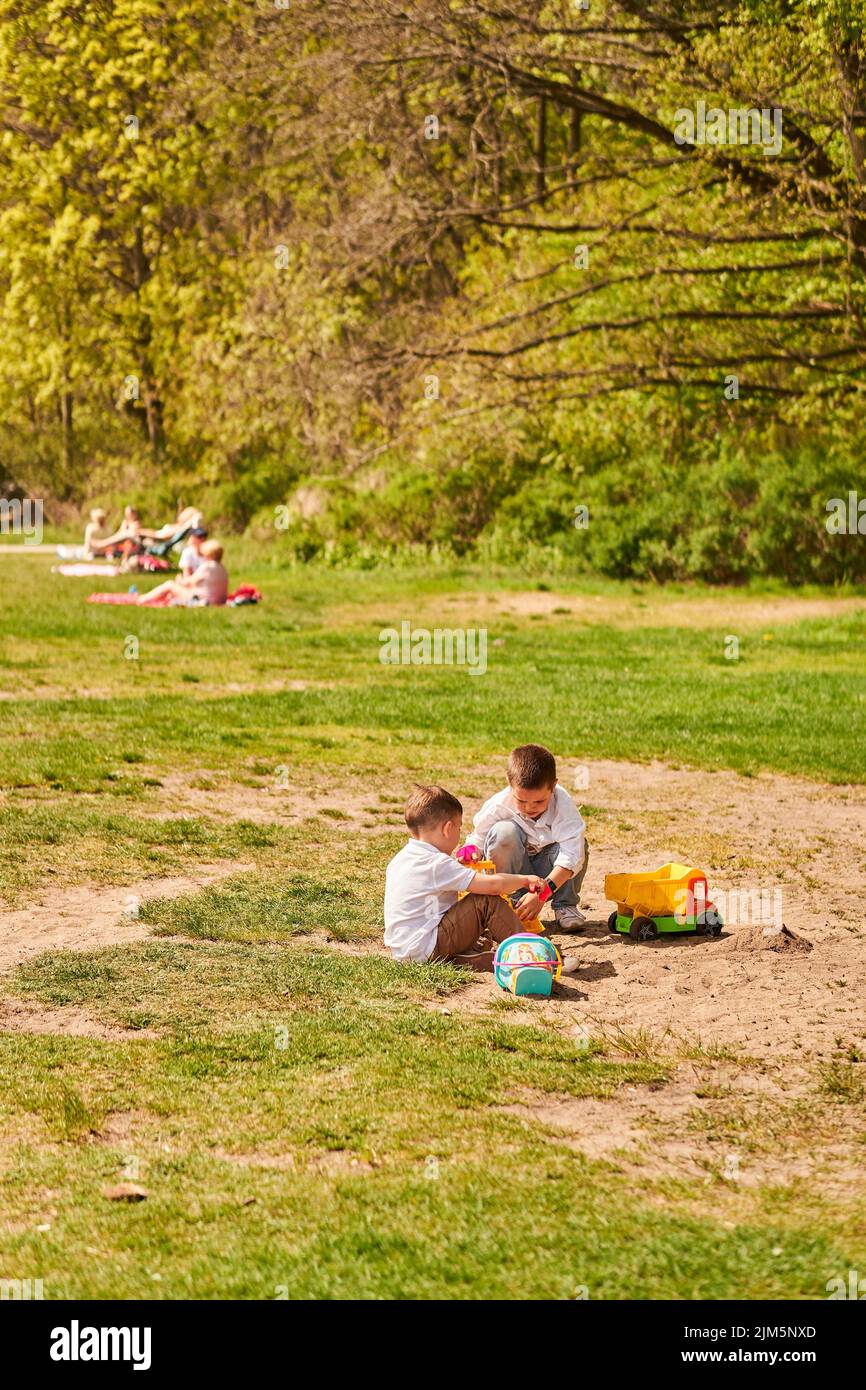 The two boys playing with toys on sand in the park in Poznan, Poland ...