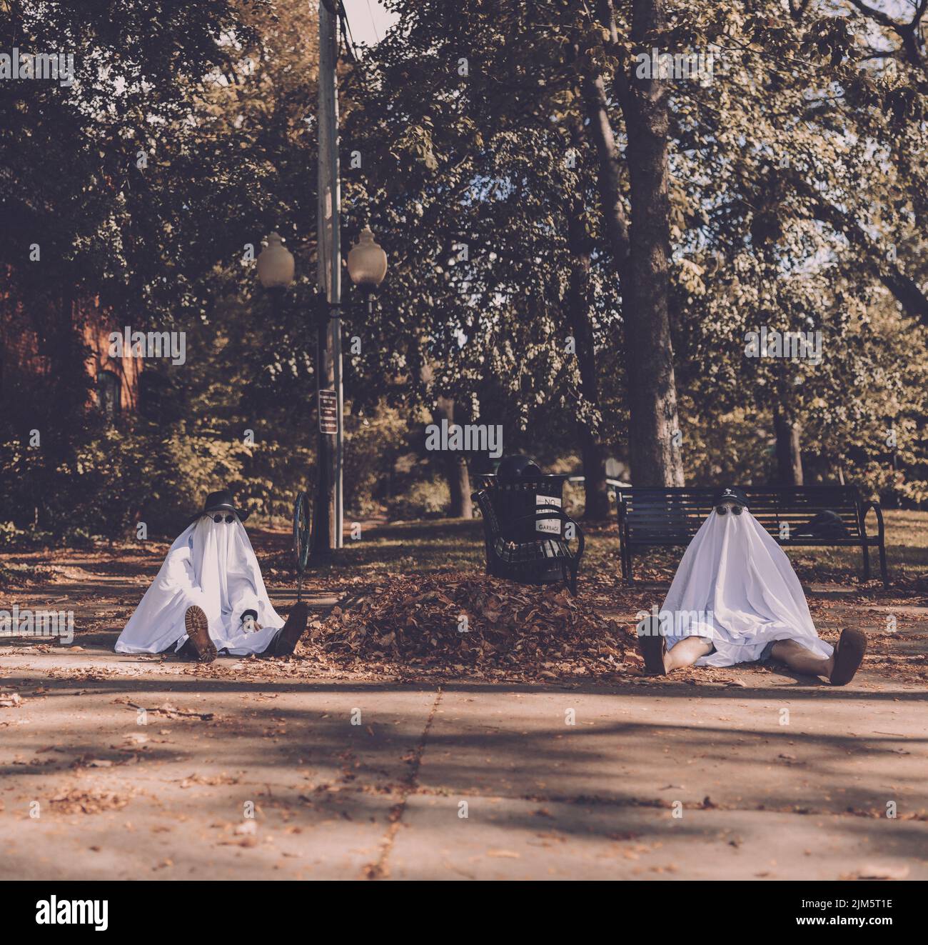 Ghost Couple sitting with fall leaves Stock Photo - Alamy