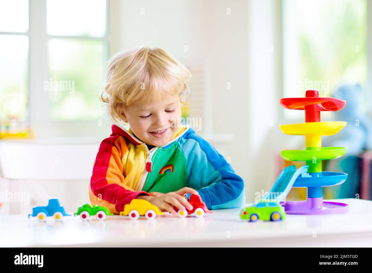 Little boy playing toy cars. Young kid with colorful educational ...