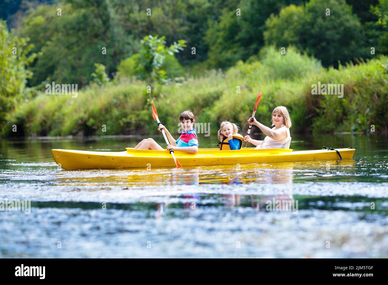 Child with paddle on kayak. Summer camp for kids. Kayaking and canoeing ...