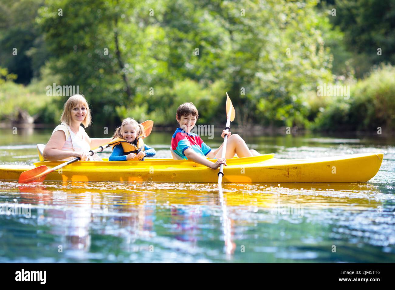 Child with paddle on kayak. Summer camp for kids. Kayaking and canoeing ...