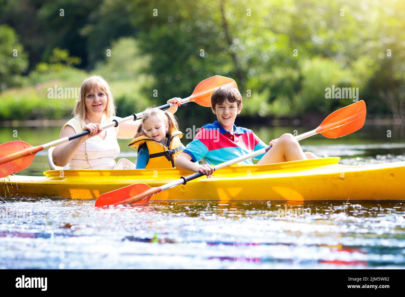 Child with paddle on kayak. Summer camp for kids. Kayaking and canoeing ...