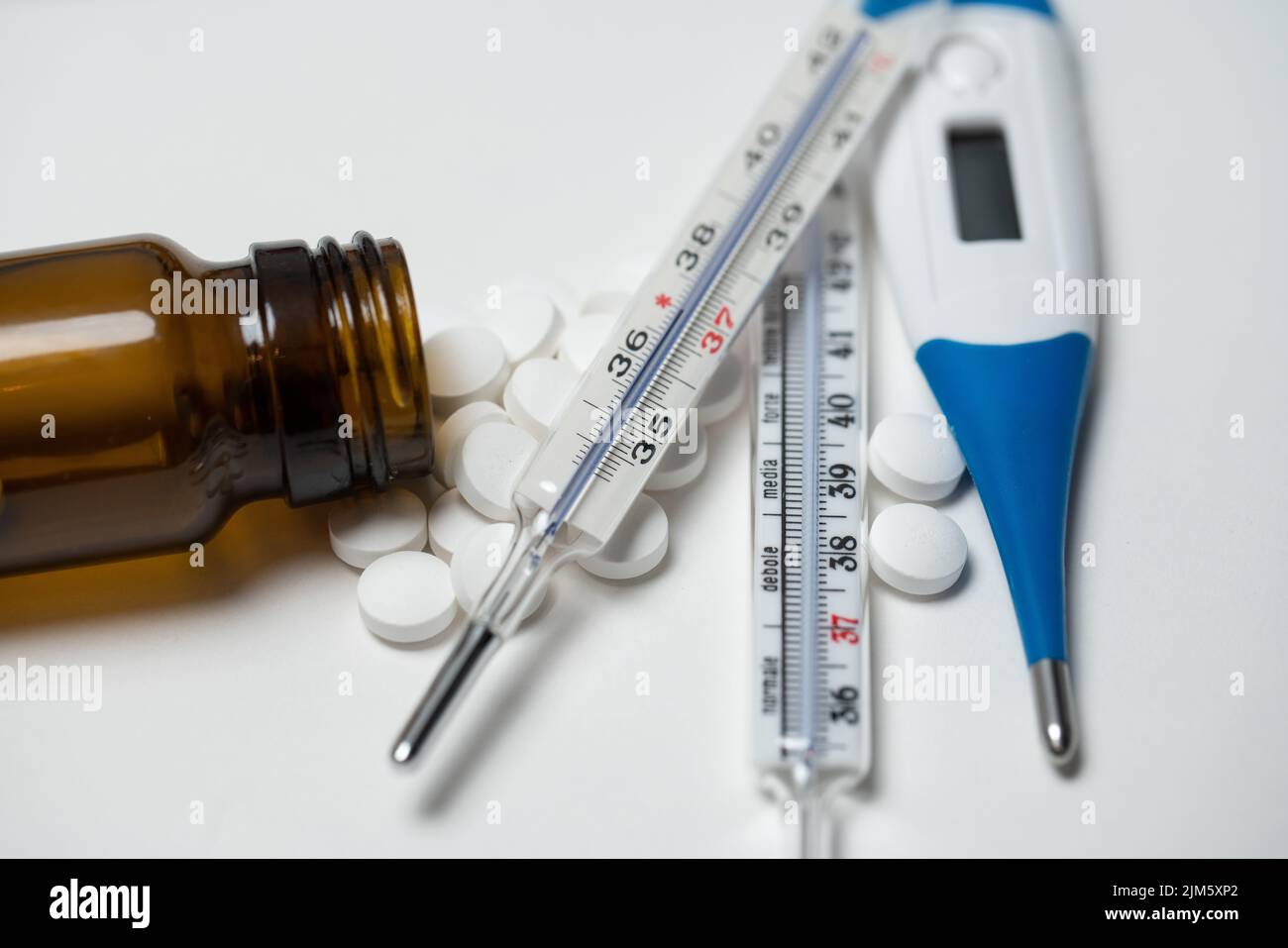 A top view of an analog and digital thermometer on a white surface with ...