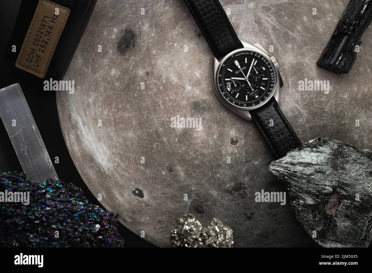 A top view of a Bulova Moon Watch on moon surface texture surrounded by ...
