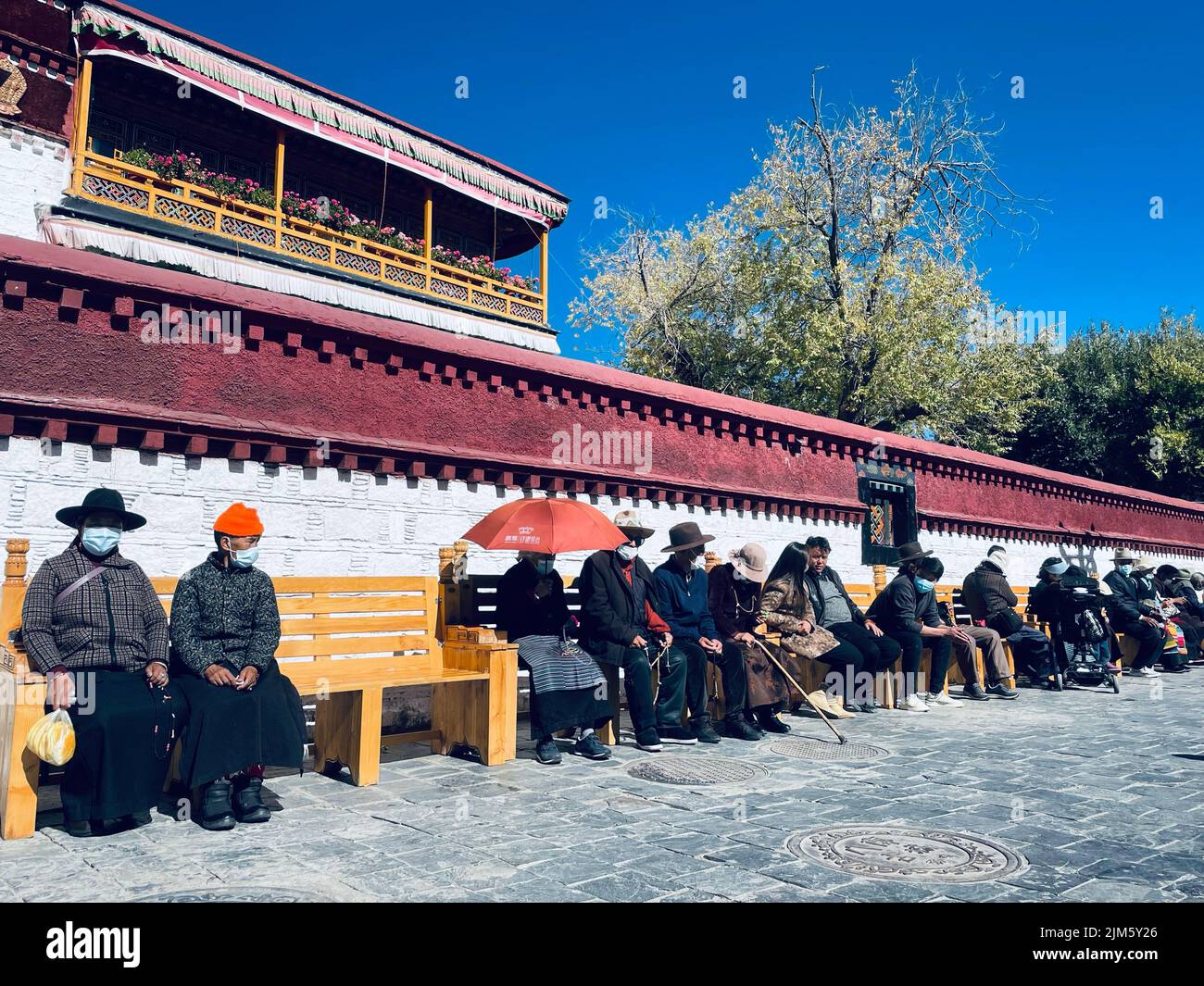 A beautiful shot of people sitting in a line in Potala Palace Fortress ...