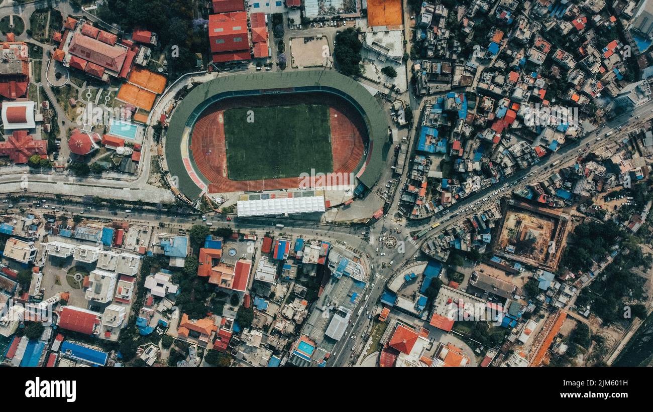 An aerial shot of the Dashrath Stadium and city buildings in bright ...