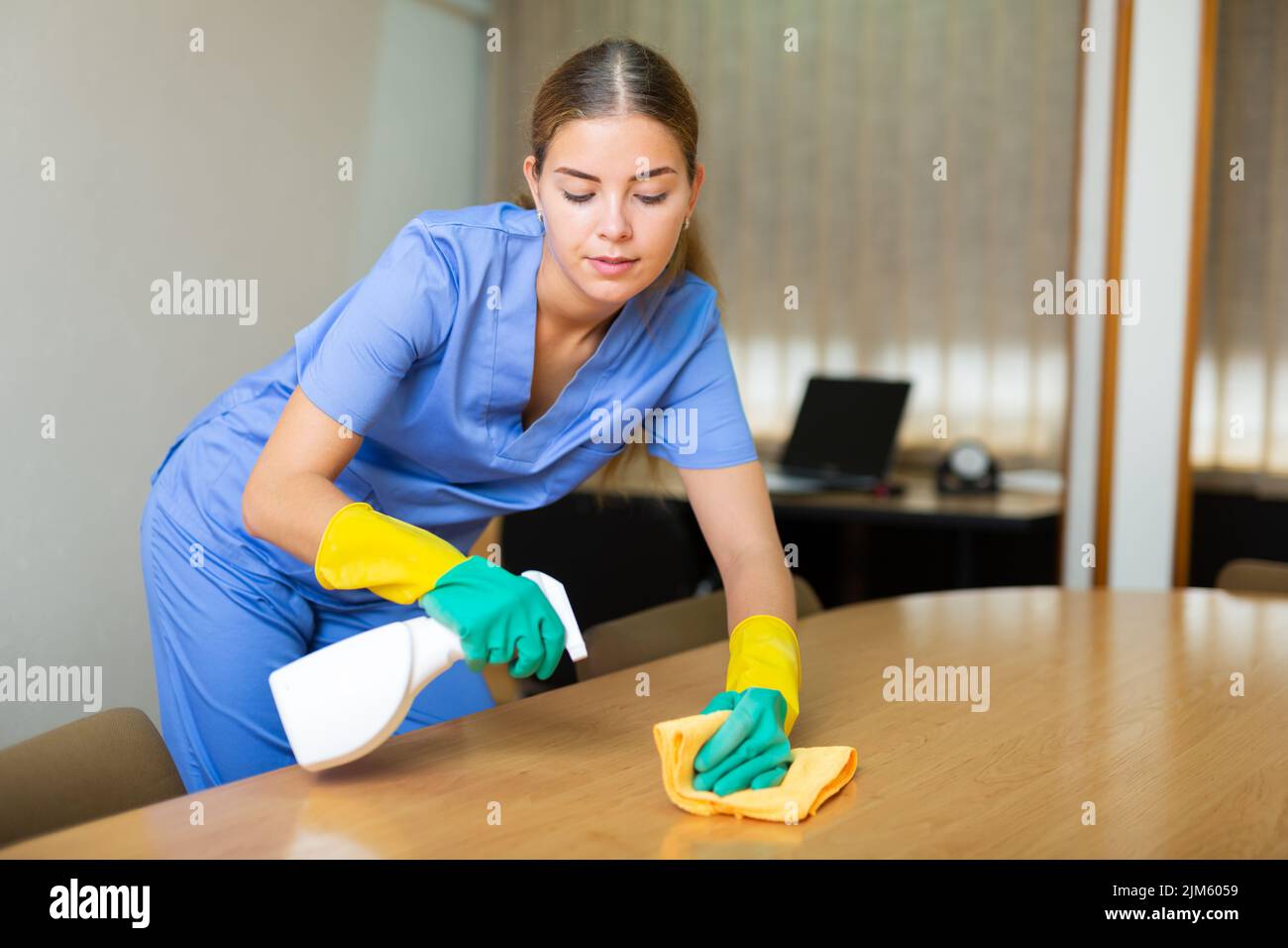 Portrait of a young female worker cleaning an office desk Stock Photo ...